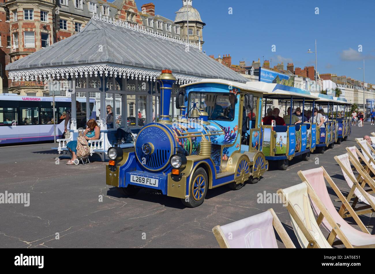 A colourful tourist mini train travels along the seafront at Weymouth ...