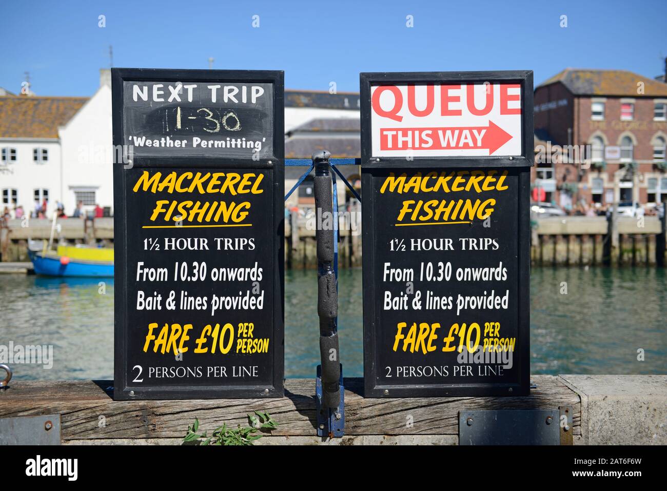Signs advertising mackerel fishing boat trips by the harbourside at ...