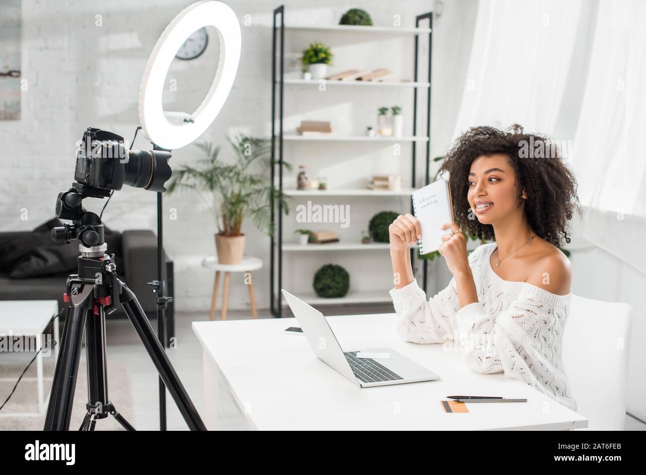 happy african american video blogger in braces holding notebook with ...
