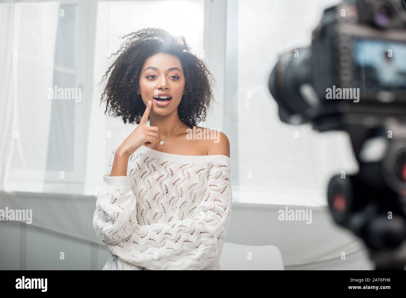 selective focus of surprised african american influencer in braces ...