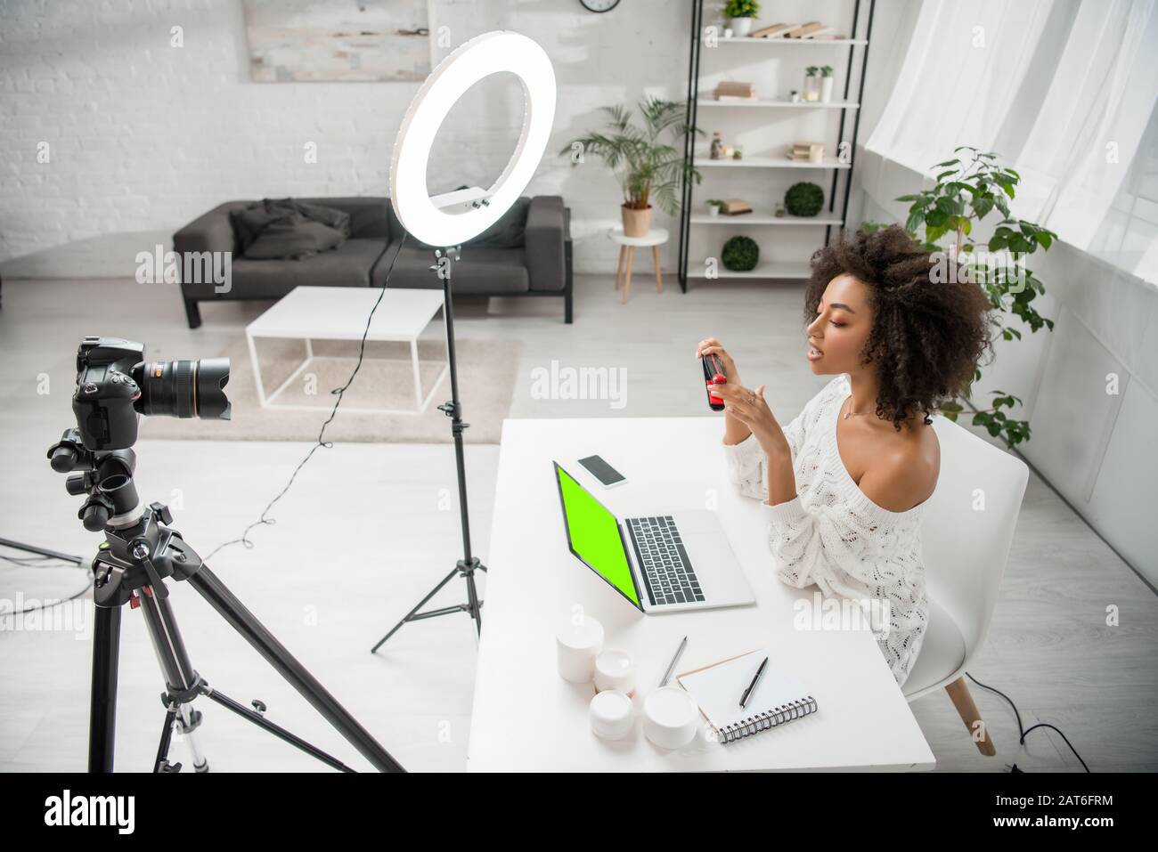 african american influencer holding hair straightener near digital ...