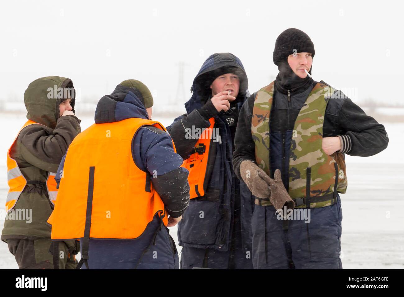 Four workers on the ice of a frozen pond near a lane Stock Photo - Alamy