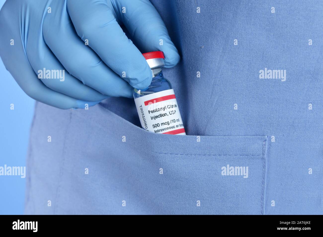 Gloved hand of healthcare worker slips fentanyl vial into pocket of ...