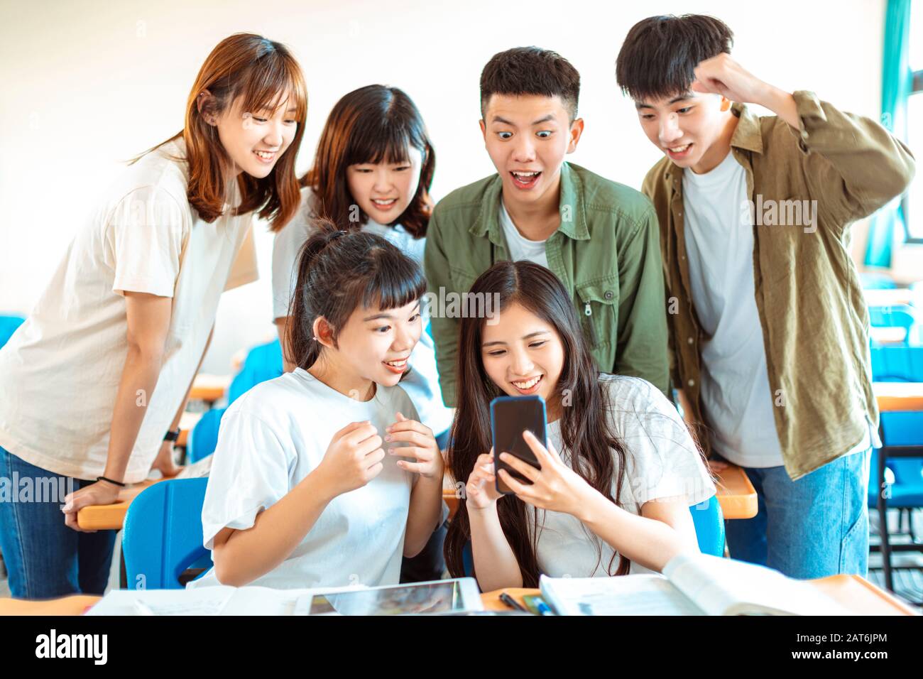 happy students looking at smartphones in classroom Stock Photo - Alamy