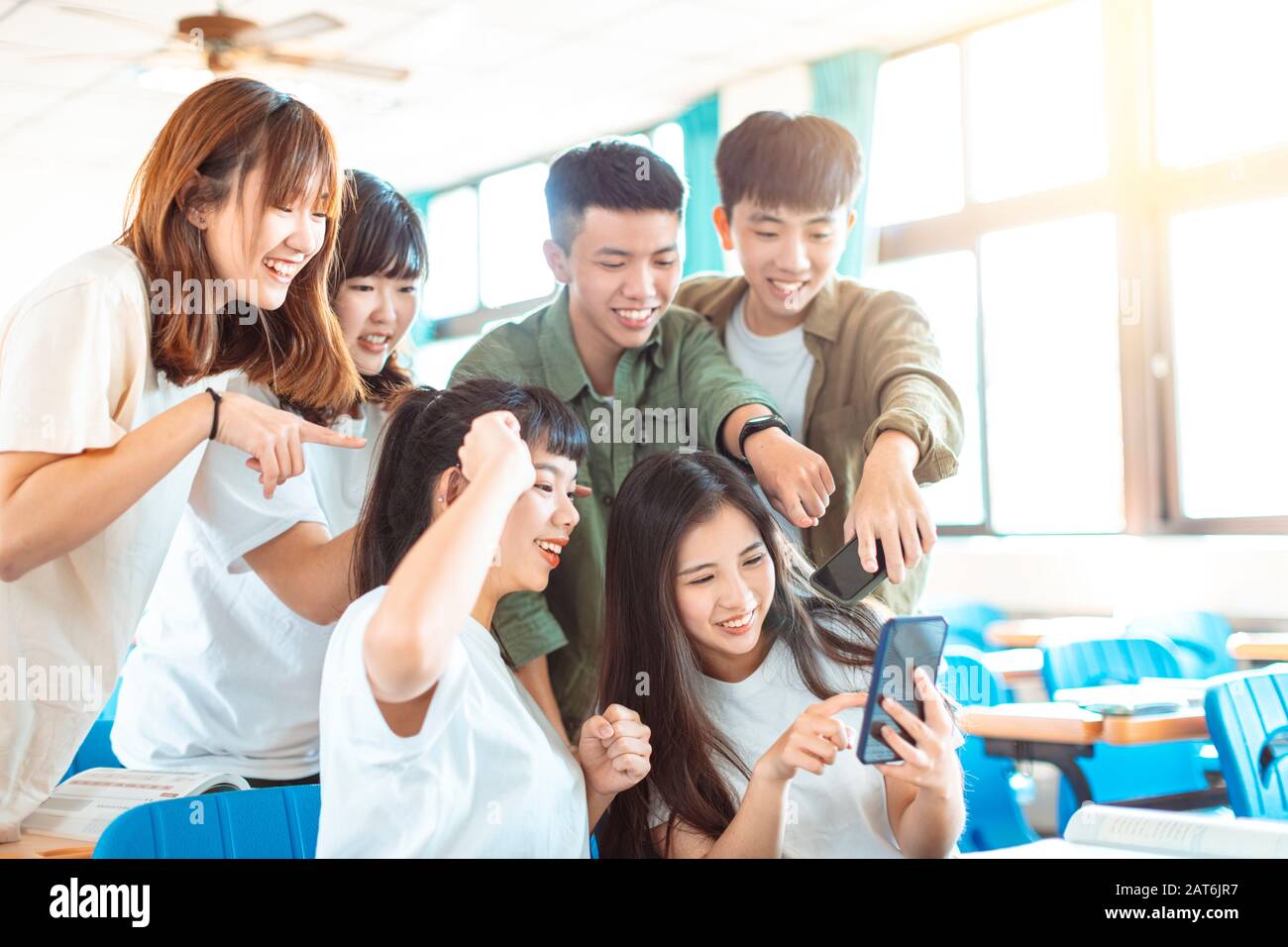 happy students looking at smartphones in classroom Stock Photo - Alamy