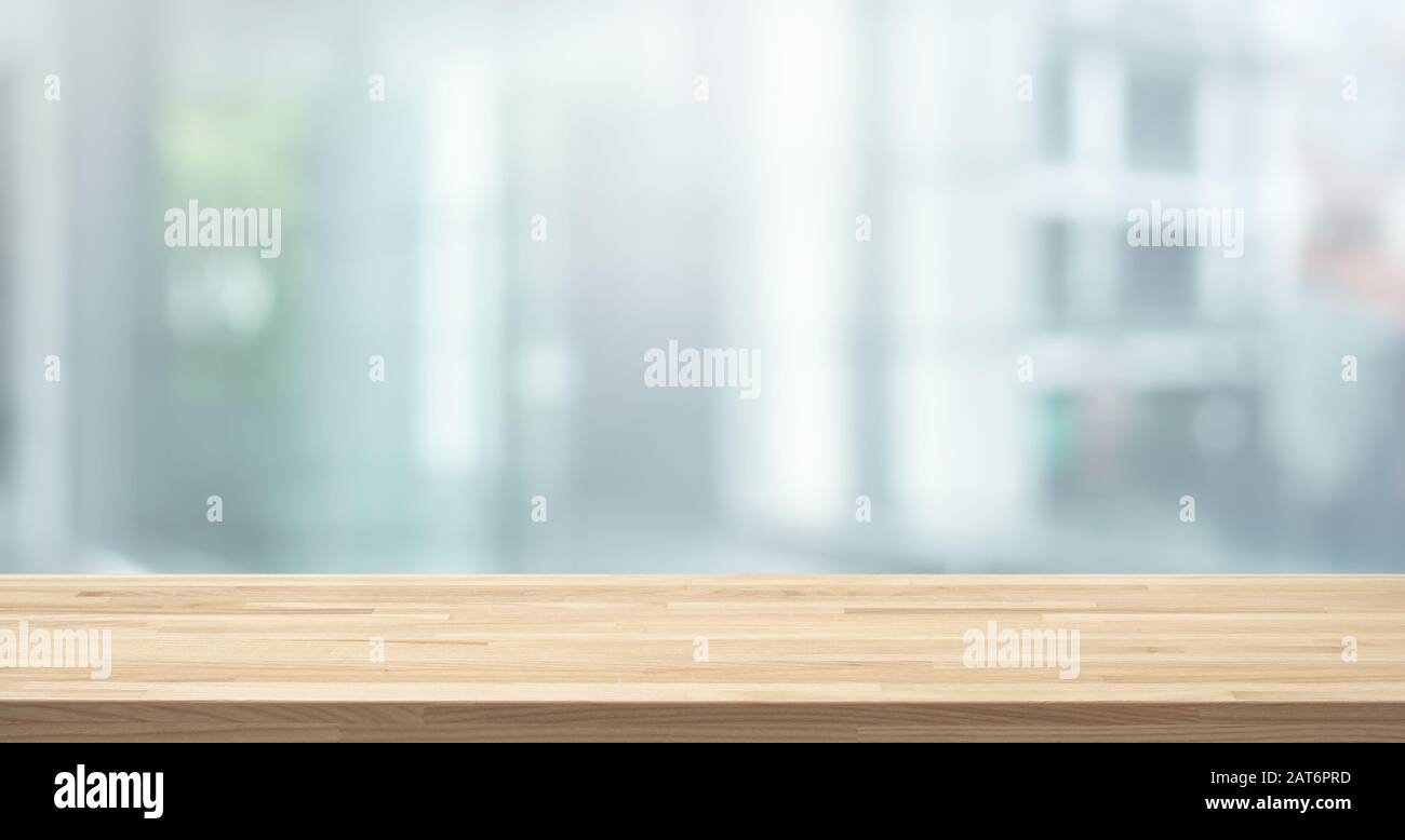 Selective focus of wood table top on white wall glass (big window ...