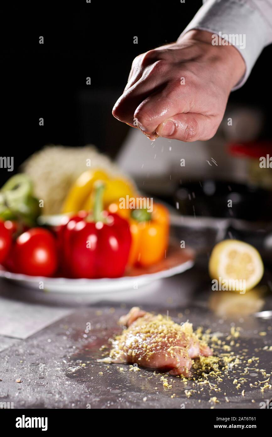 Chief chops and marinates chicken. Professional chef in a kitchen of ...