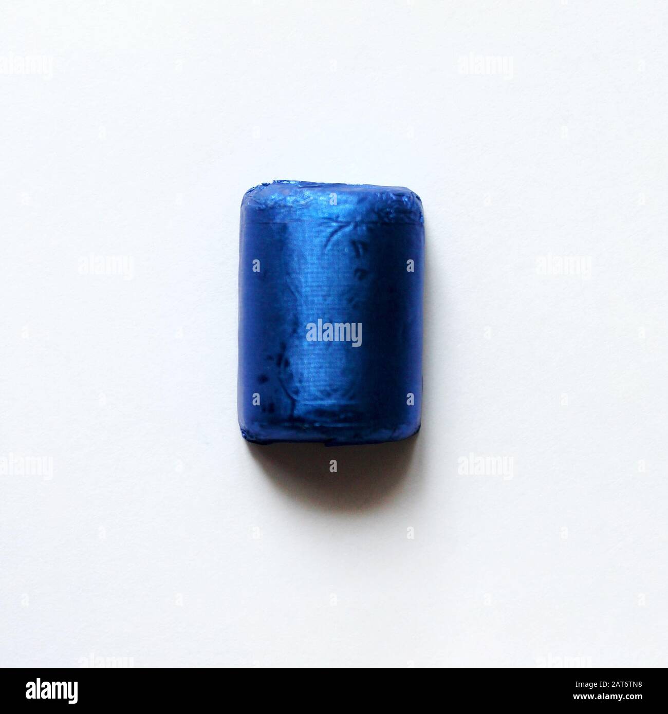 Chocolate candy wrapped in blue foil isolated on white surface. Object ...