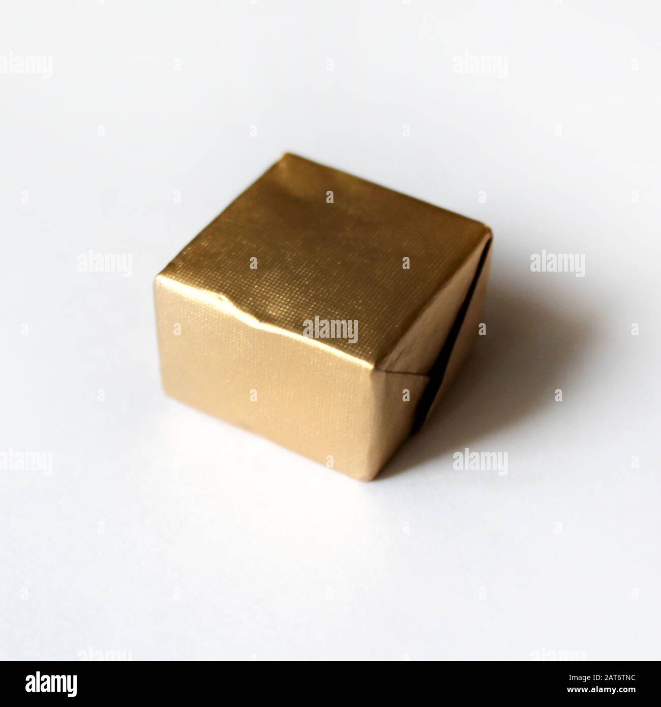 Square chocolate candy wrapped in blue foil isolated on white surface ...