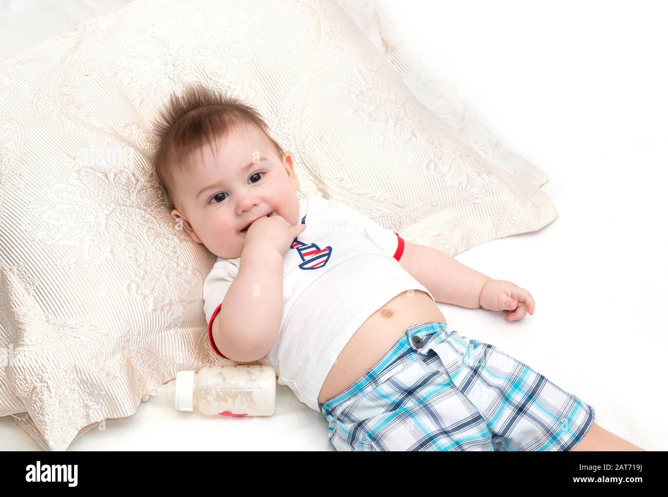 Little beautiful satisfied baby lying near empty bottle of food Stock ...