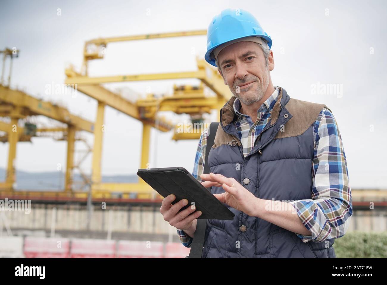 Mature construction worker inspecting work sight with tablet Stock ...
