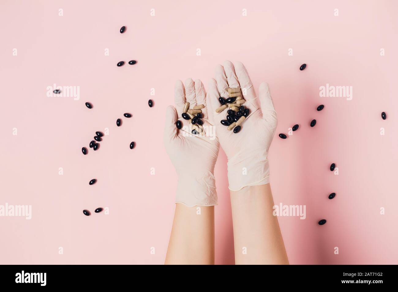 Hand in medical glove with tablets on pink background. Flat lay, top ...