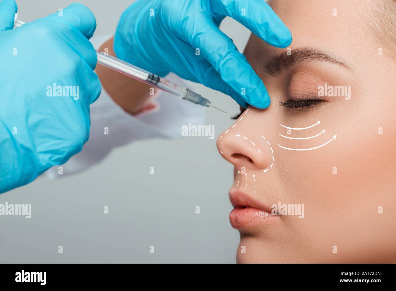 cropped view of cosmetologist making beauty injection in nose to ...