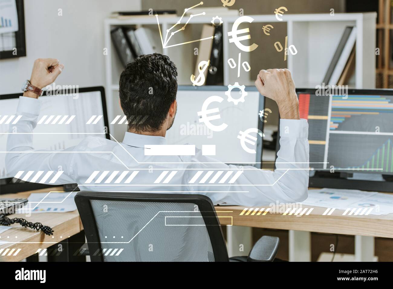 back view of trader showing yes gesture and sitting near computers with ...