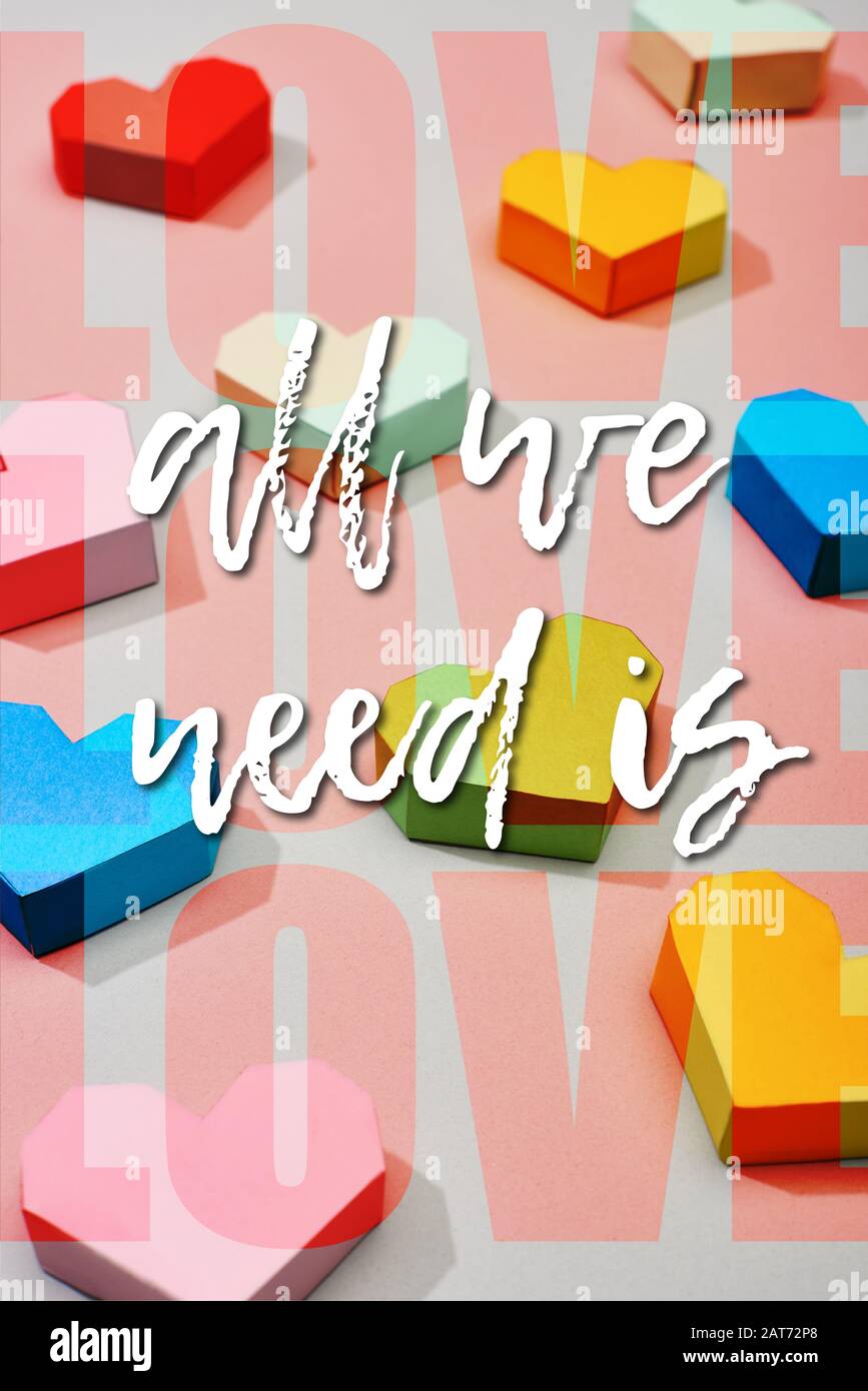 Decorative multicolored hearts on grey background with all we need is ...