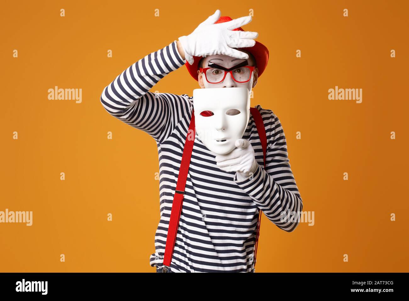 Mime clown in red hat and in vest with white mask on blank orange ...