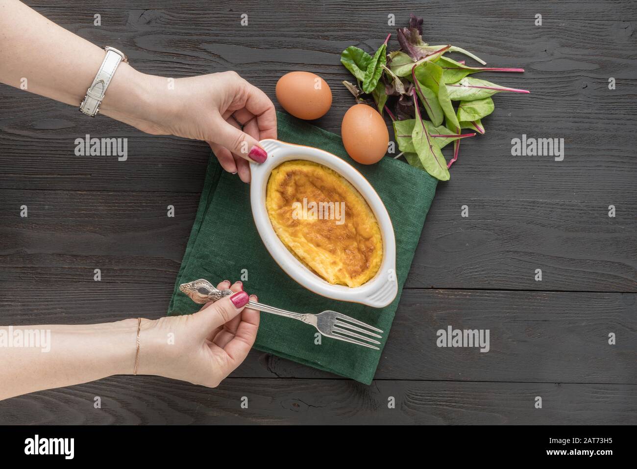 Spring omelette with green for kid in a skillet over rustic wooden ...