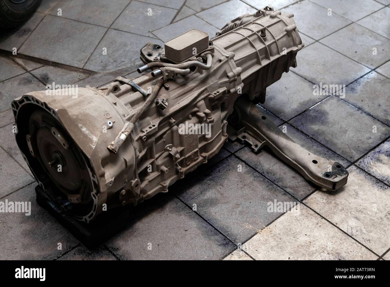 The used gearbox removed from the car on the floor among other parts in ...