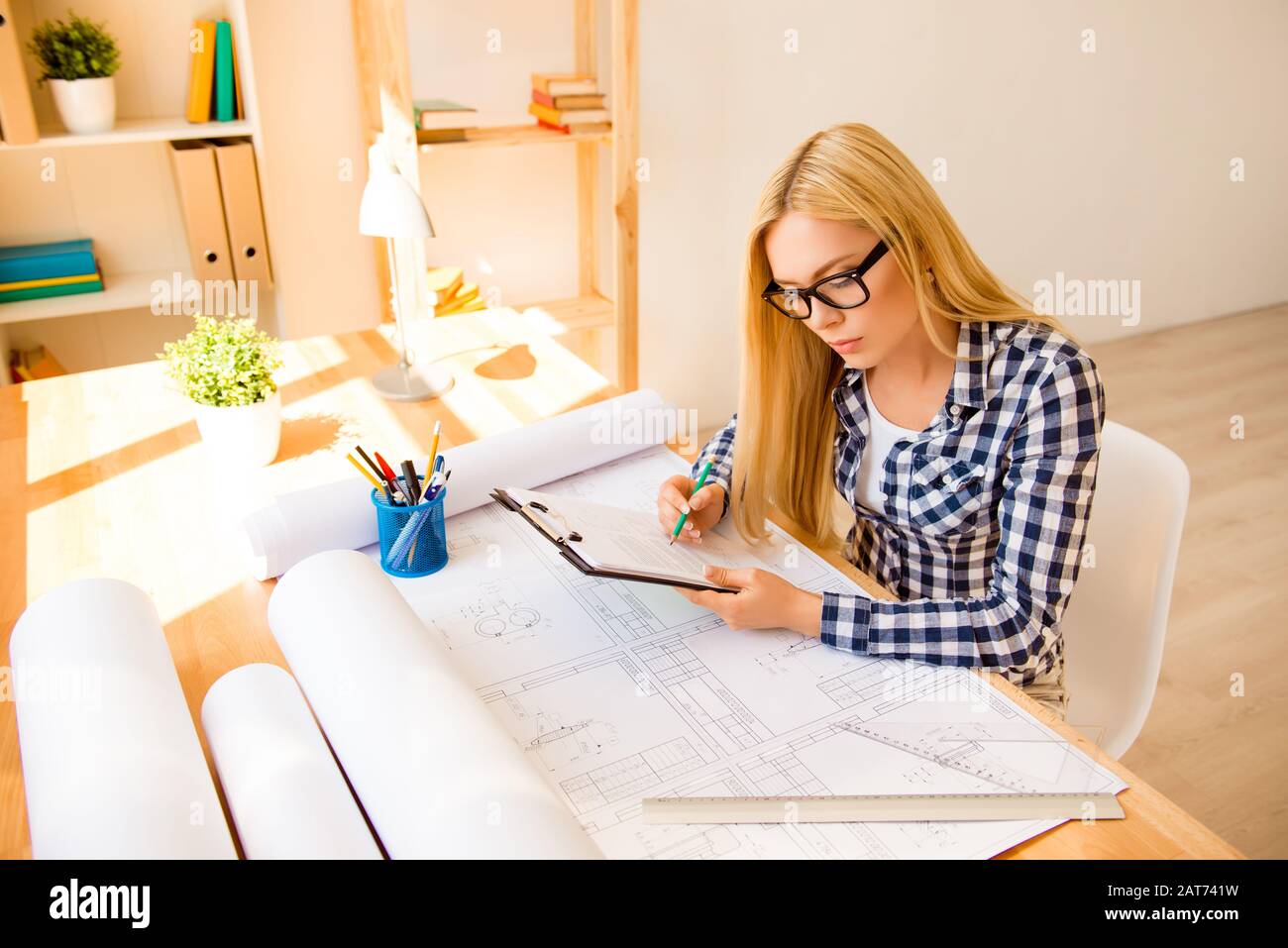 Smart girl writing in folder details of new plan Stock Photo - Alamy
