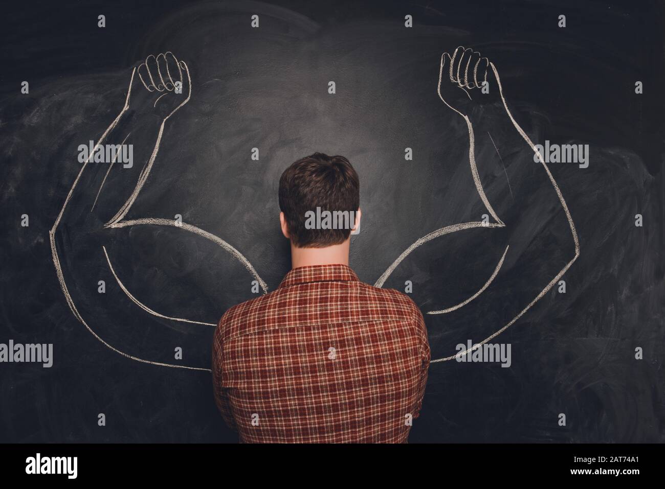 Photo of man's back. Two strong muscular arms painted on chalkboard ...