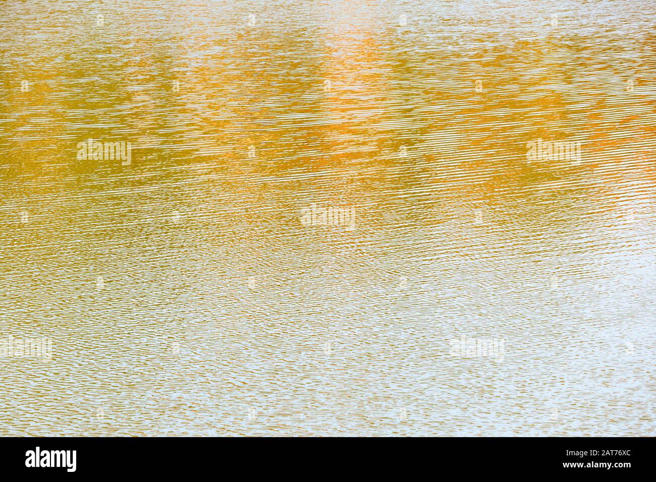 Vivid orange and golden tones reflect in water on an early morning fall ...