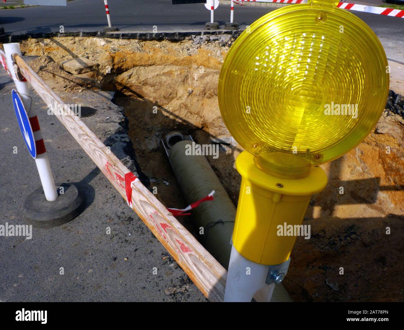 road barrier made of red and white wooden planks on plastic posts with ...