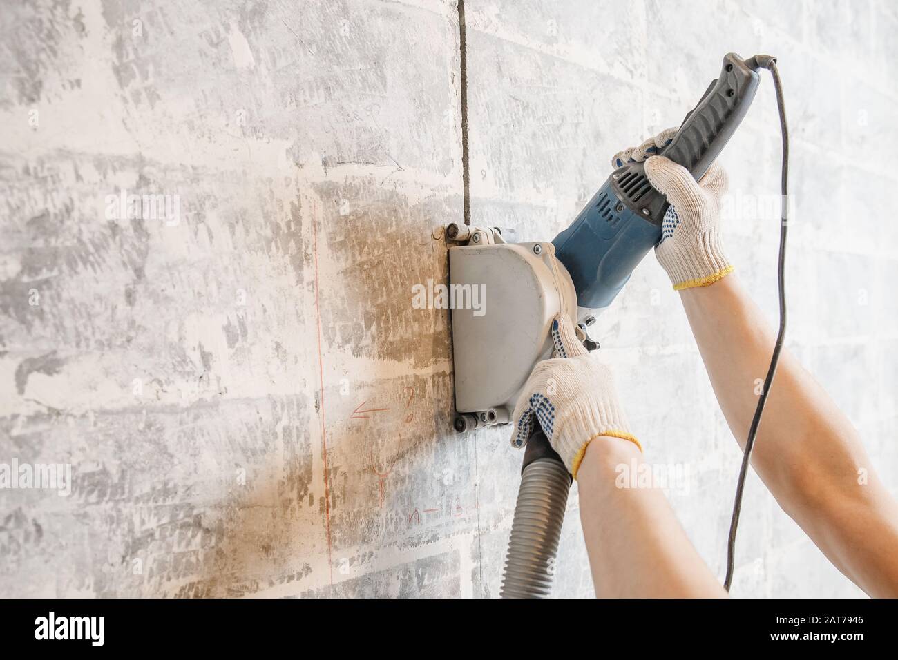 Builder man cutting electrical chase in concrete wall with groove ...