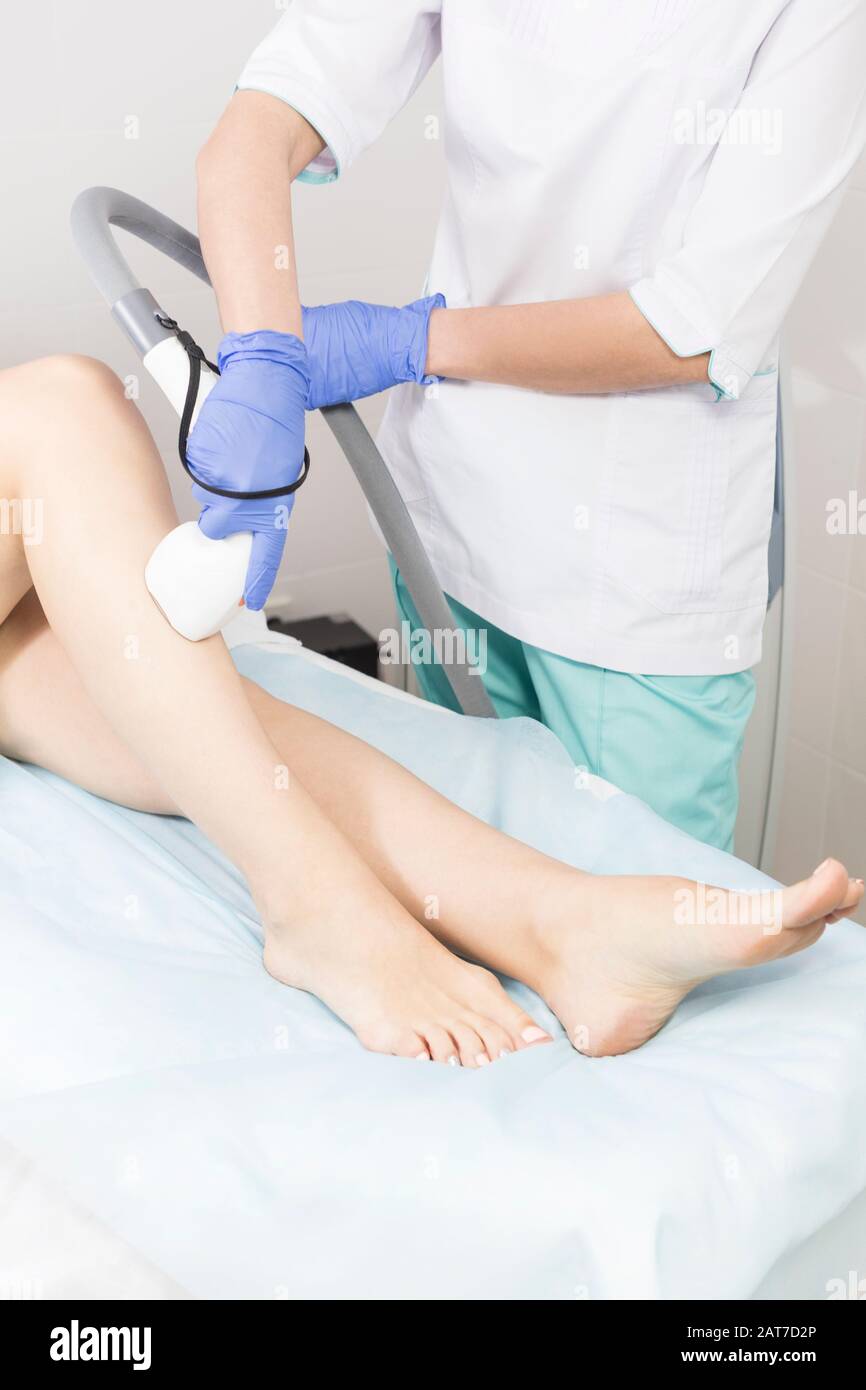 The process of laser depilation of female limbs in the beauty salon ...