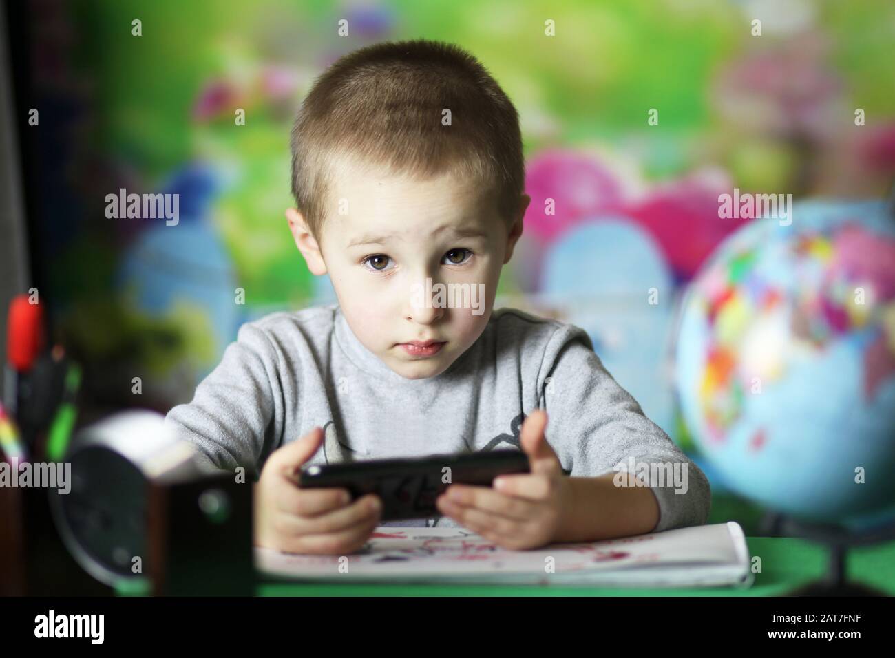 Child with a gadget. Little serious boy. Four year old child with a ...