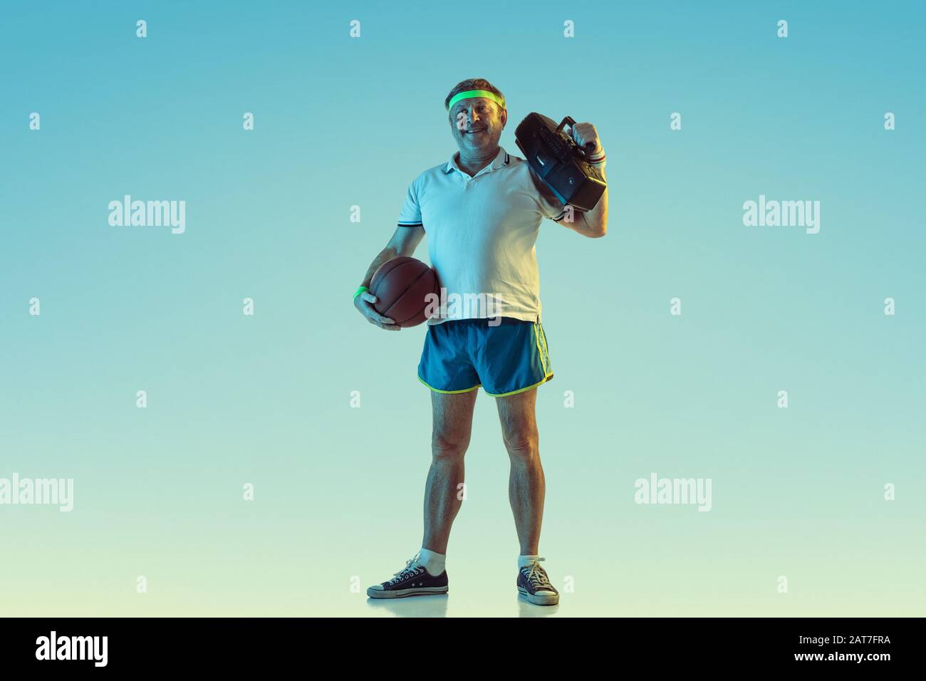 Senior man posing stunning in sportwear with retro tape recorder on ...