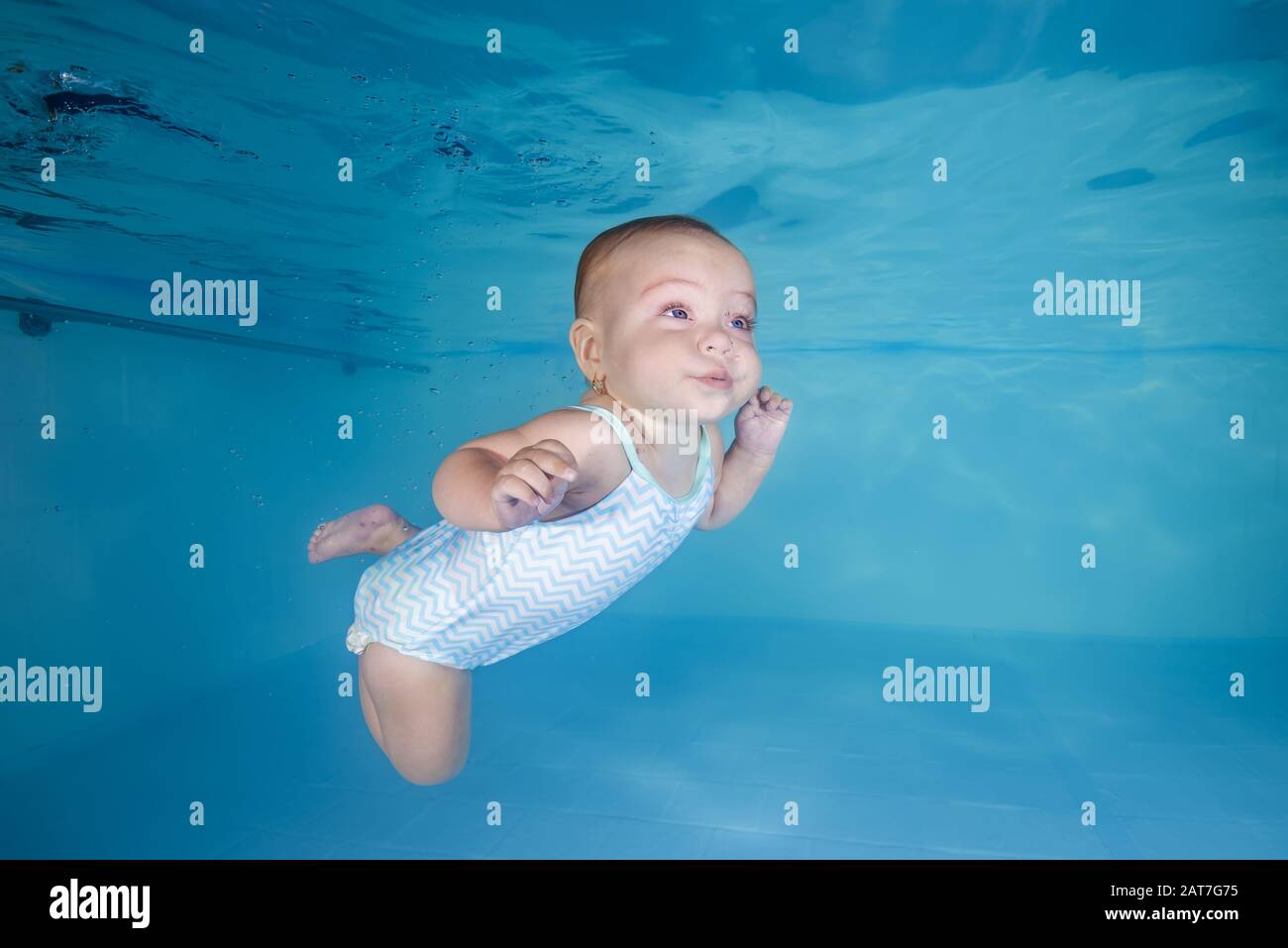 Little baby learning to swim underwater in a swimming pool hi-res stock ...