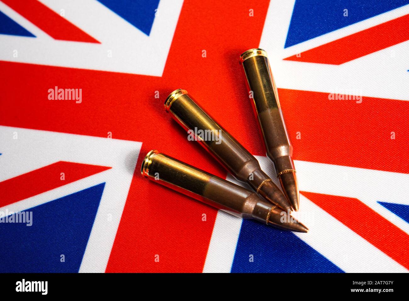 Three rifle cartridges on the flag of Great Britain. Close-up, copy ...