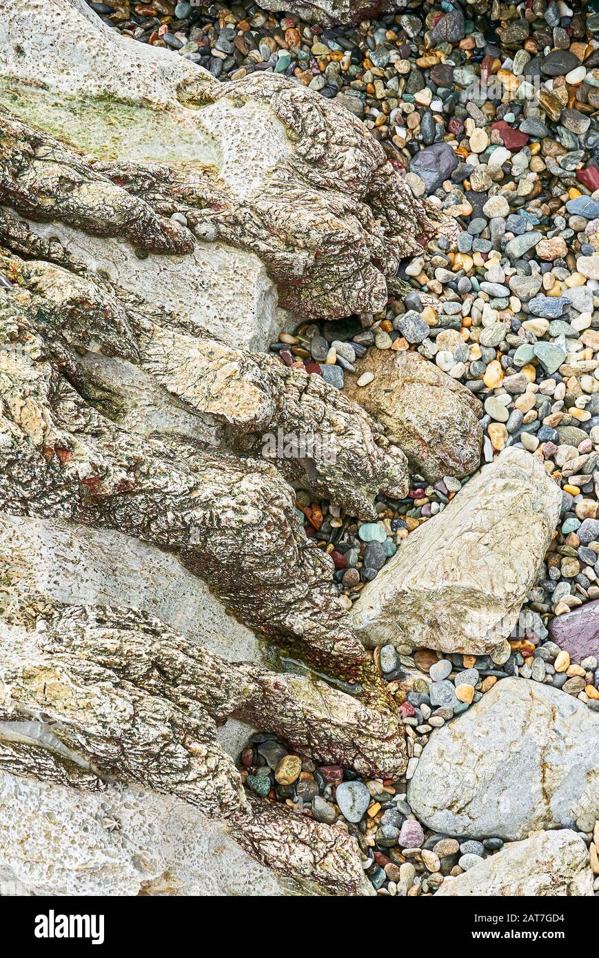 Array of gray colored, textured eroded rock, framed by other stones and ...