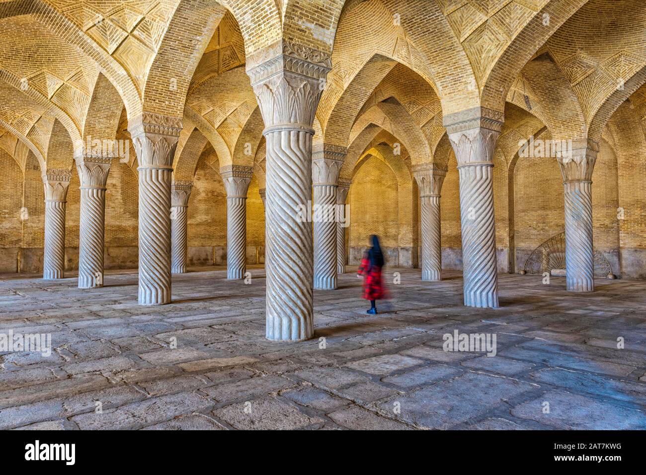 Iranian woman walking through the prayer hall with Shabestan pillars ...