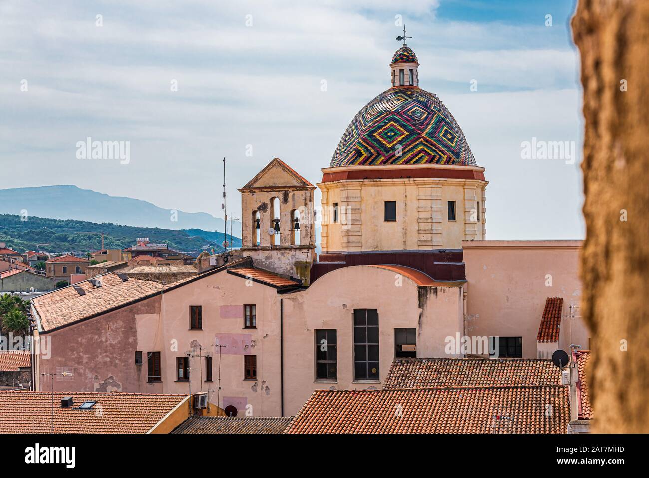 The colorful dome of a church in the old town of Alghero in Sardinia ...