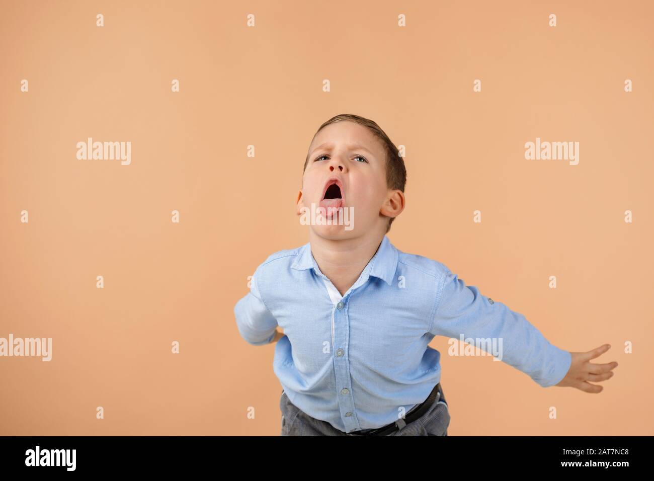 little child boy screaming on beige background Stock Photo - Alamy