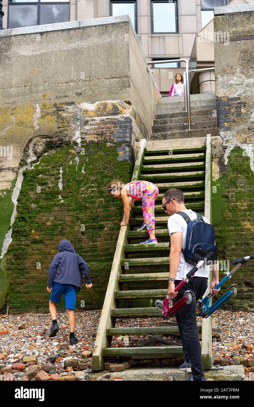 A family make their way off the Thames foreshore, a popular place for ...
