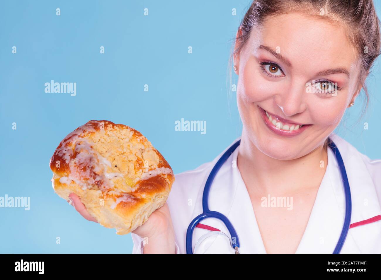 Dietitian nutritionist holding sweet roll bun. Woman with fattening ...