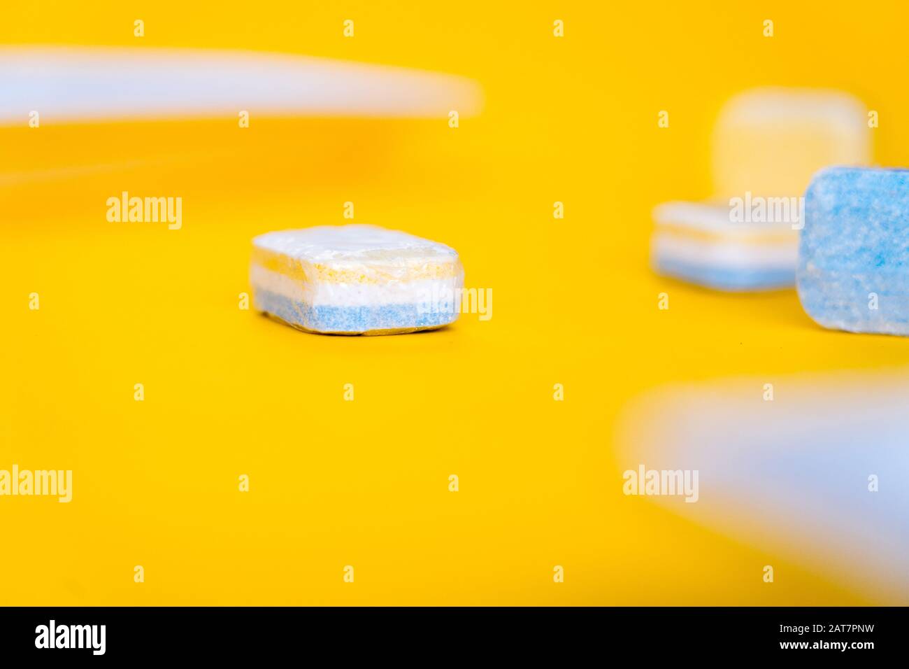 Cleaning dishwasher tablets on a yellow background. Group of bright ...