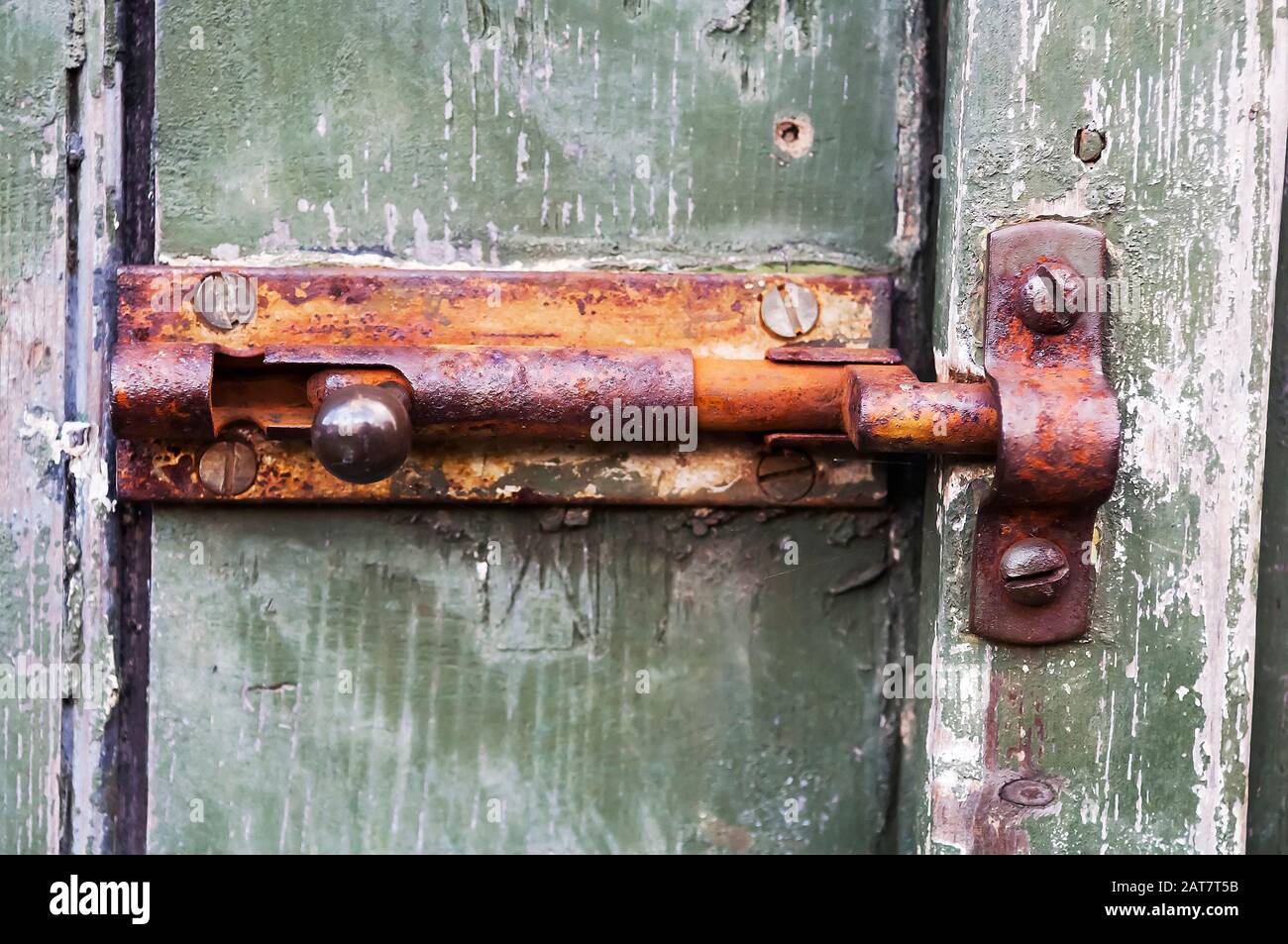 A rusty old bolt on an old green door Stock Photo - Alamy