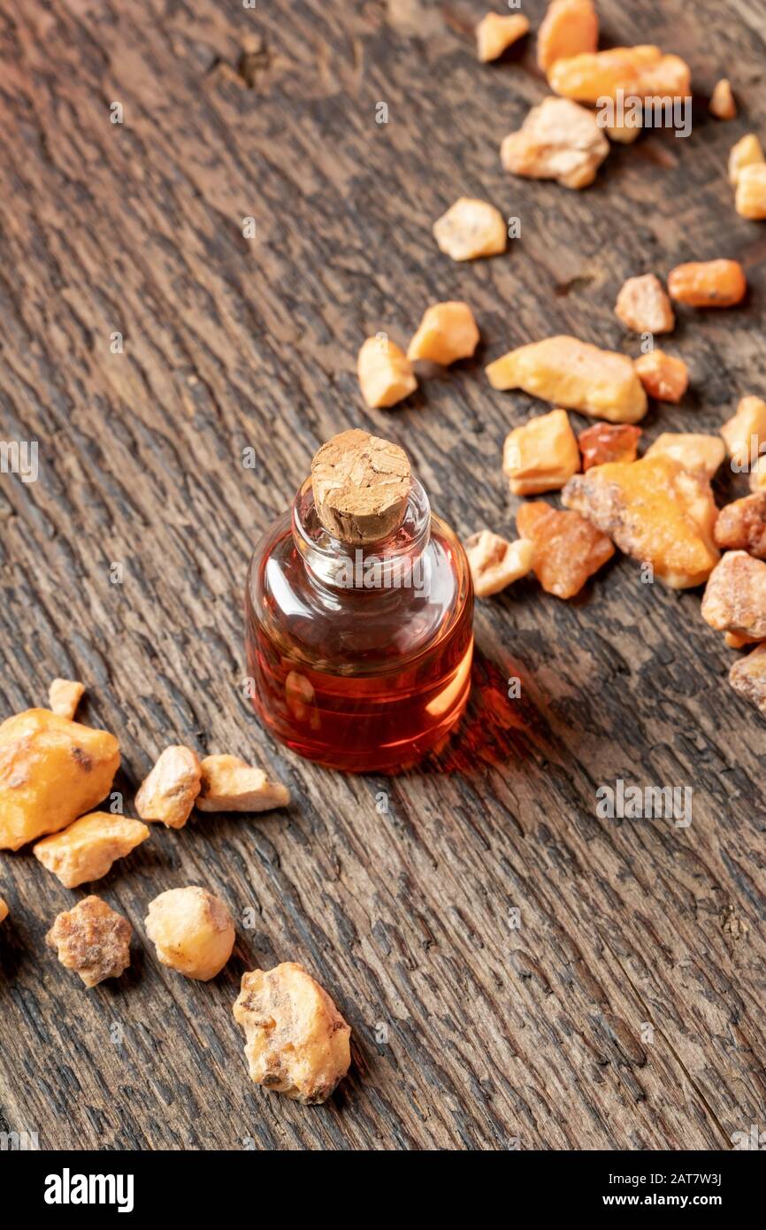 A bottle of styrax benzoin essential oil and resin on a wooden table ...