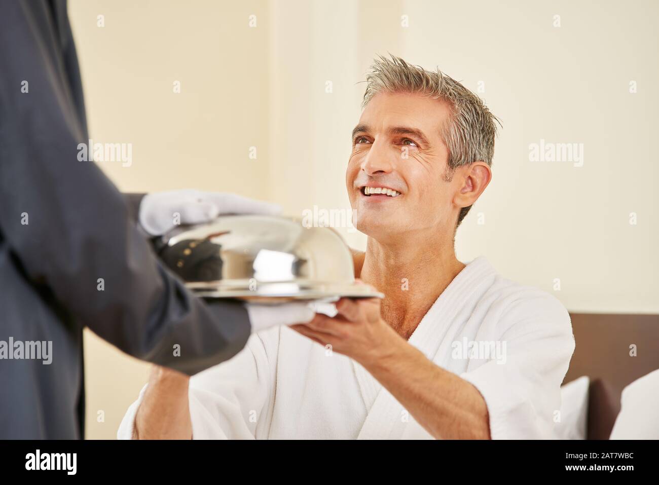 Page brings food to a man as room service at the hotel Stock Photo - Alamy