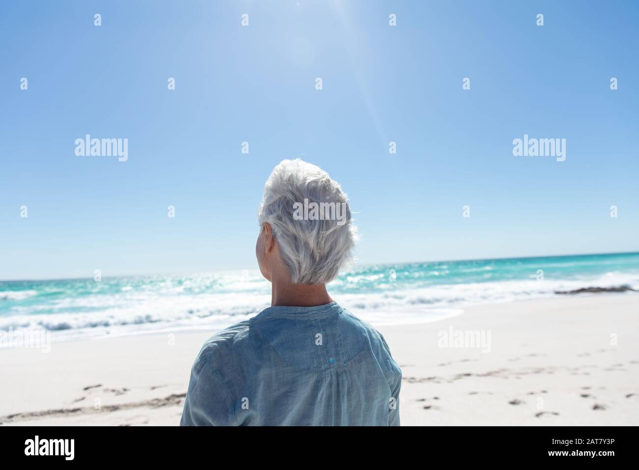 Old woman looking at the beach Stock Photo - Alamy