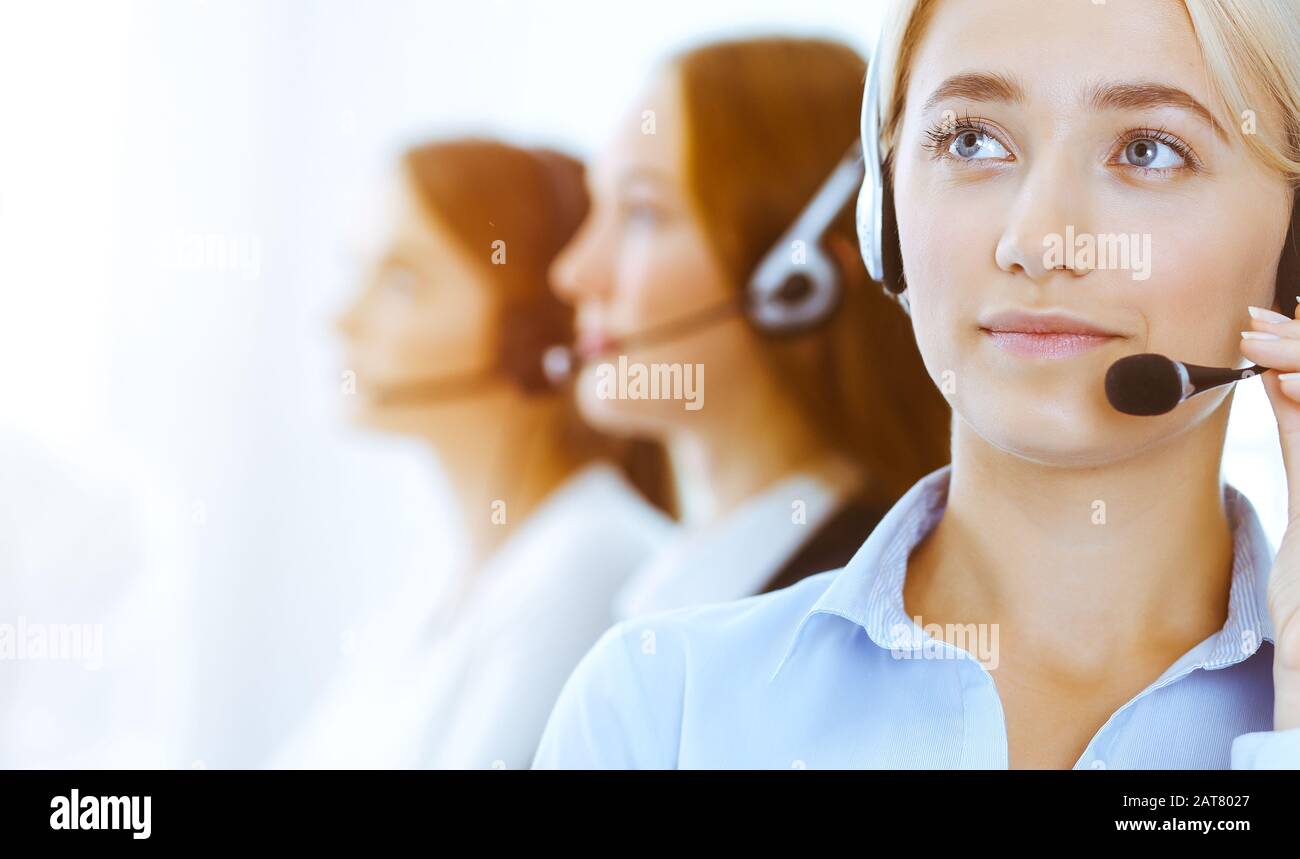 Group of diverse phone operators at work in sunny office. Handsome ...