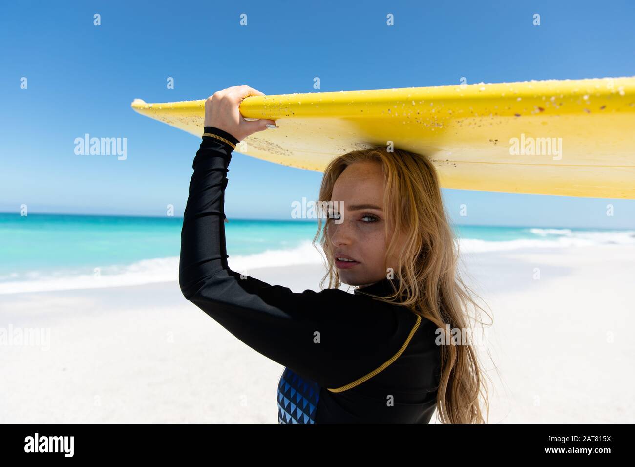 Young woman carrying a surfboard at the beach Stock Photo - Alamy
