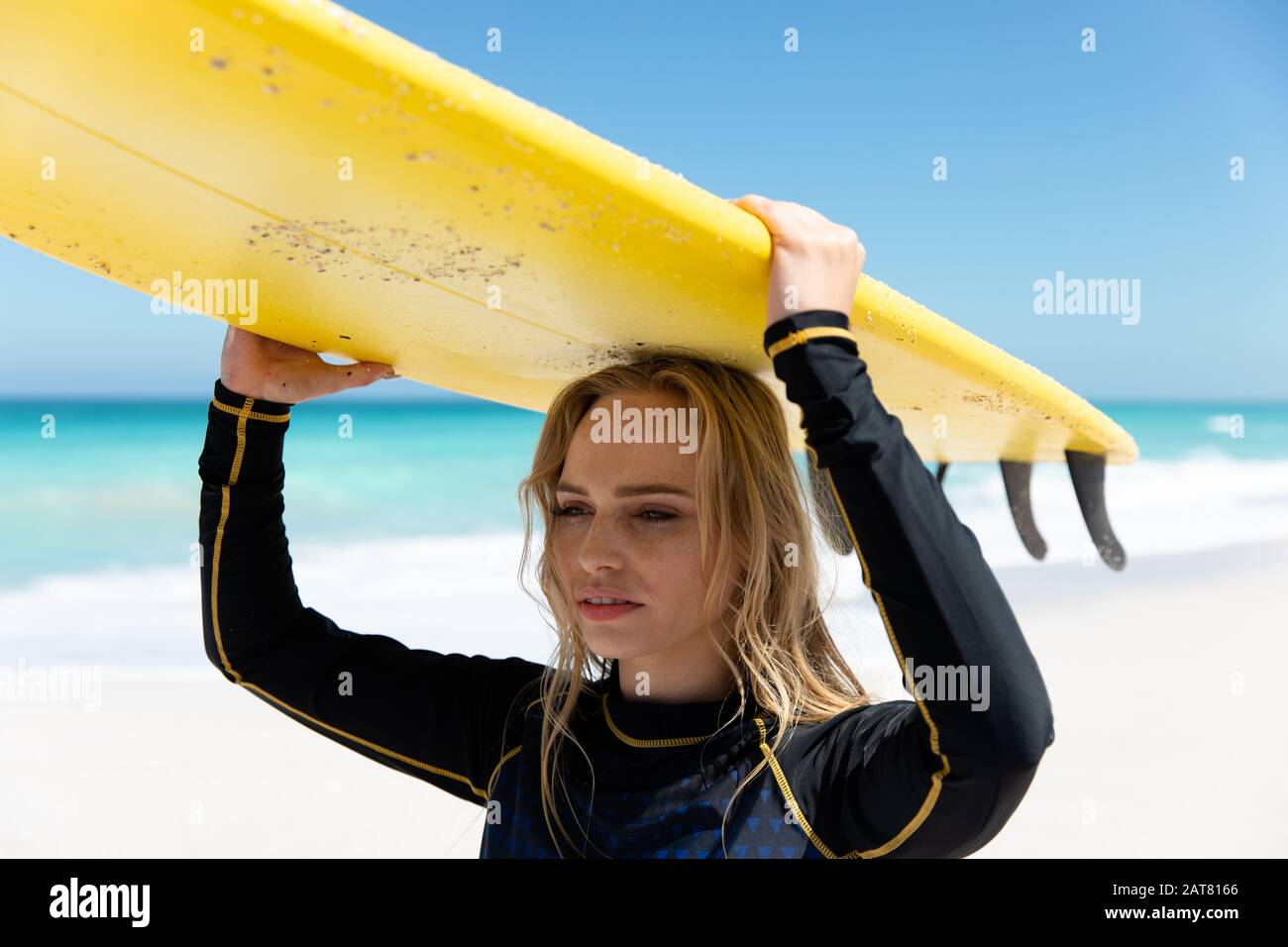Young woman carrying a surfboard at the beach Stock Photo - Alamy