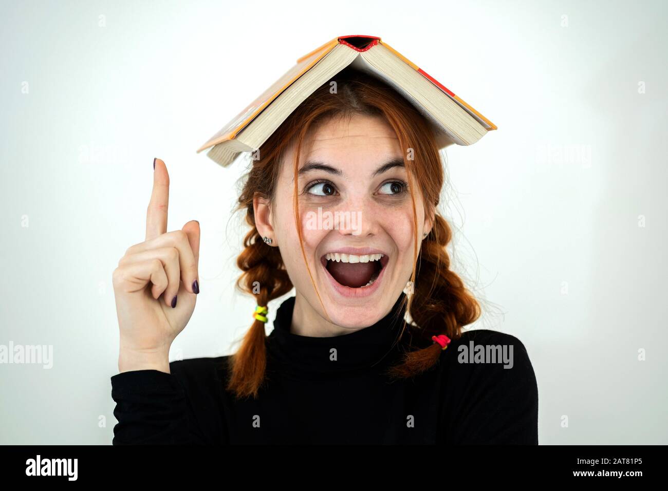 Portrait of funny young smiling student girl with an open book on her ...