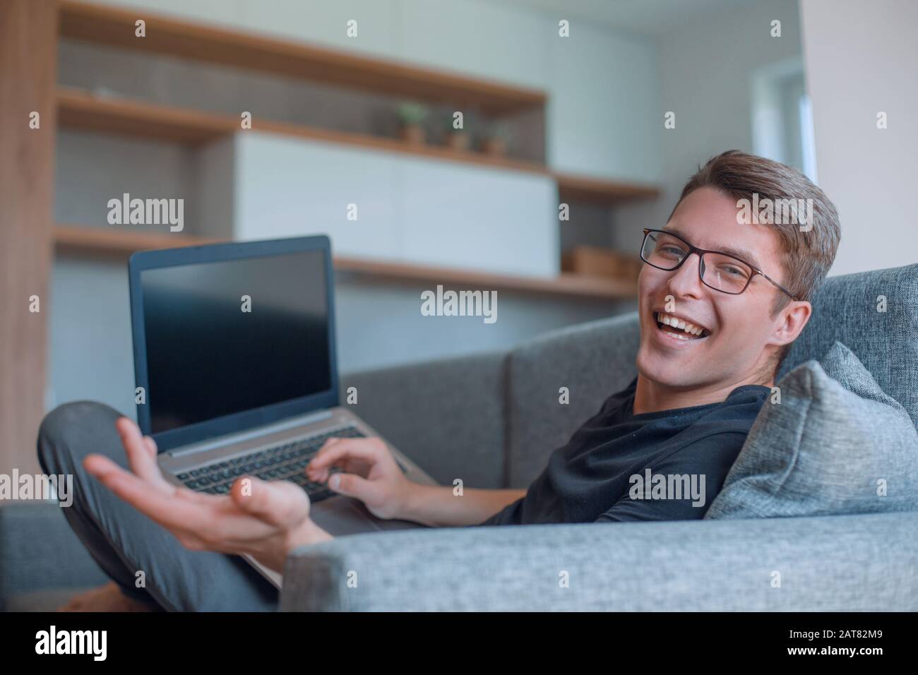 close up. happy young man lying on comfortable couch Stock Photo - Alamy