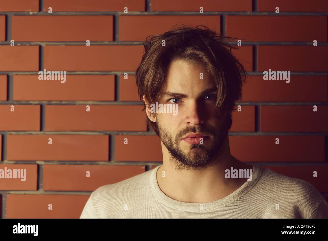 Macho man with beard, messy hair and scared or attentive face ...