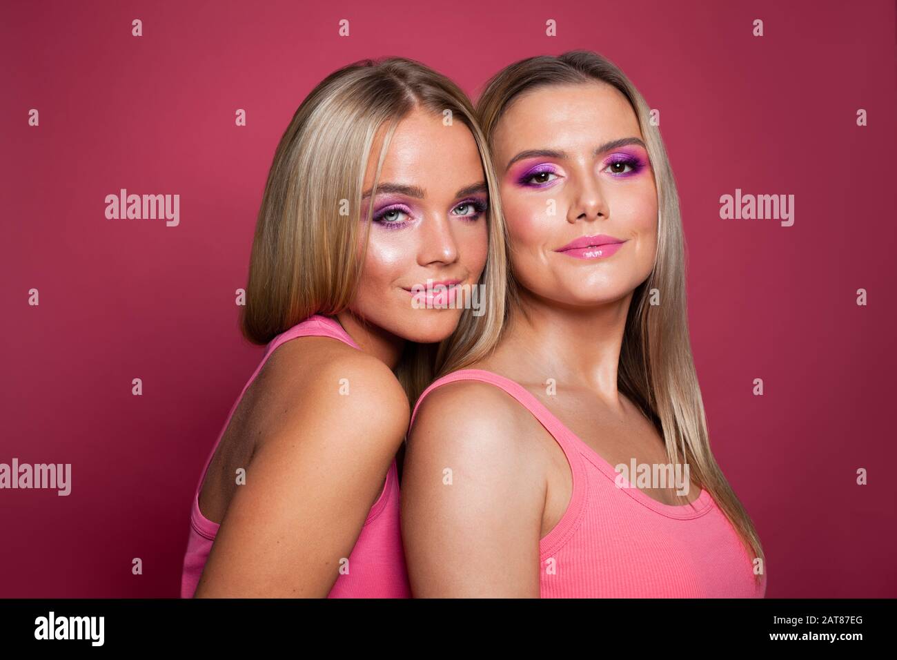 Pretty models with perfect makeup on pink background Stock Photo - Alamy
